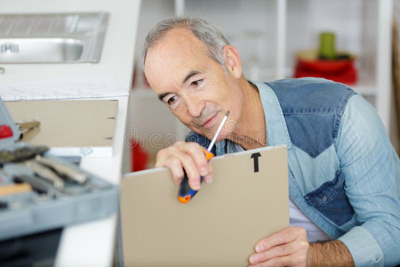 Senior Man Assembling Kitchen Cupboard Stock Photo - Image of ...