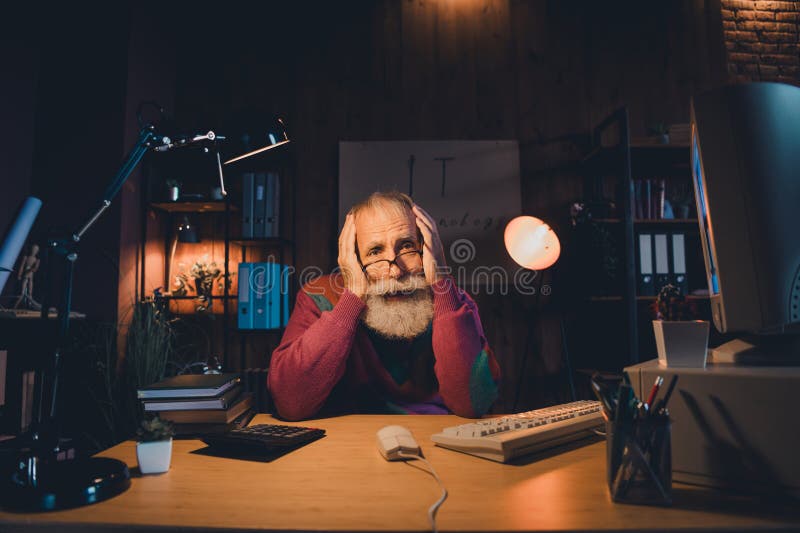 Elderly Programmer Works Late in a Cozy Home Office with Modern Technology and Stylish Light ...