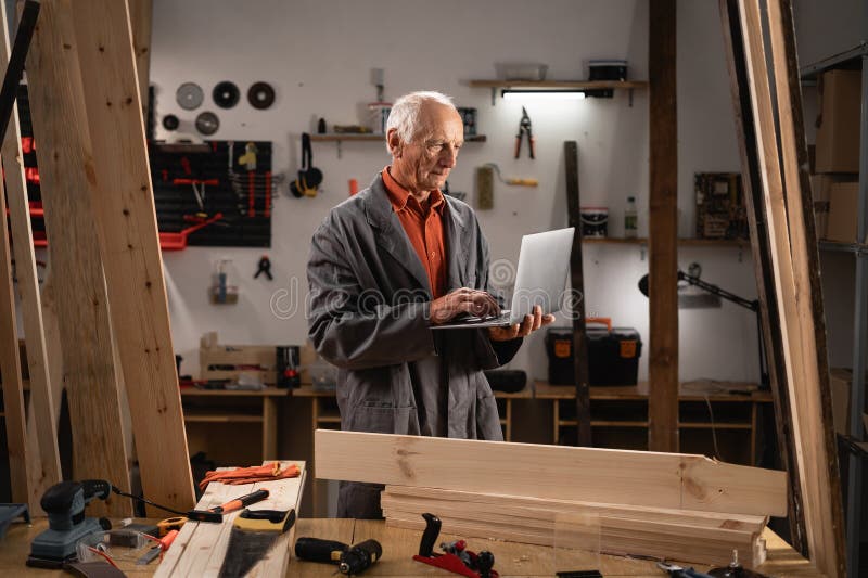 Senior Man Carpenter Working in Woodwork Workshop Using Laptop Computer ...