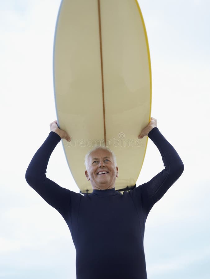 Senior Man Carrying Surfboard Over Head Stock Photo - Image of leisure ...