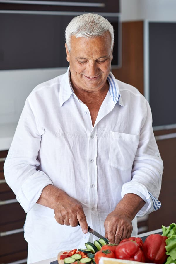 Senior Man Cooking at Home Preparing Salad in Kitchen Stock Photo ...