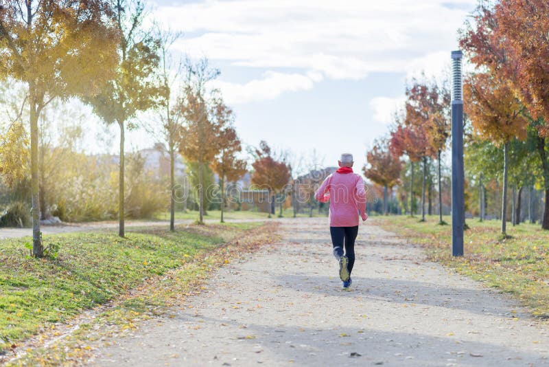 A Senior Man Dressed in Black and Green is Running in the Park Stock ...