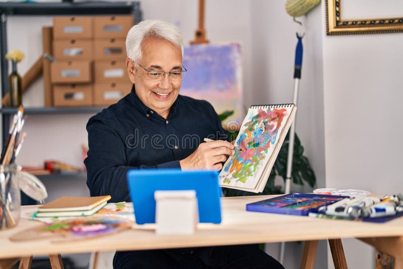 Senior Man Having Online Draw Lesson Sitting on Table at Art Studio ... Senior Man Having Online Draw Lesson Sitting on Table at Art Studio ...