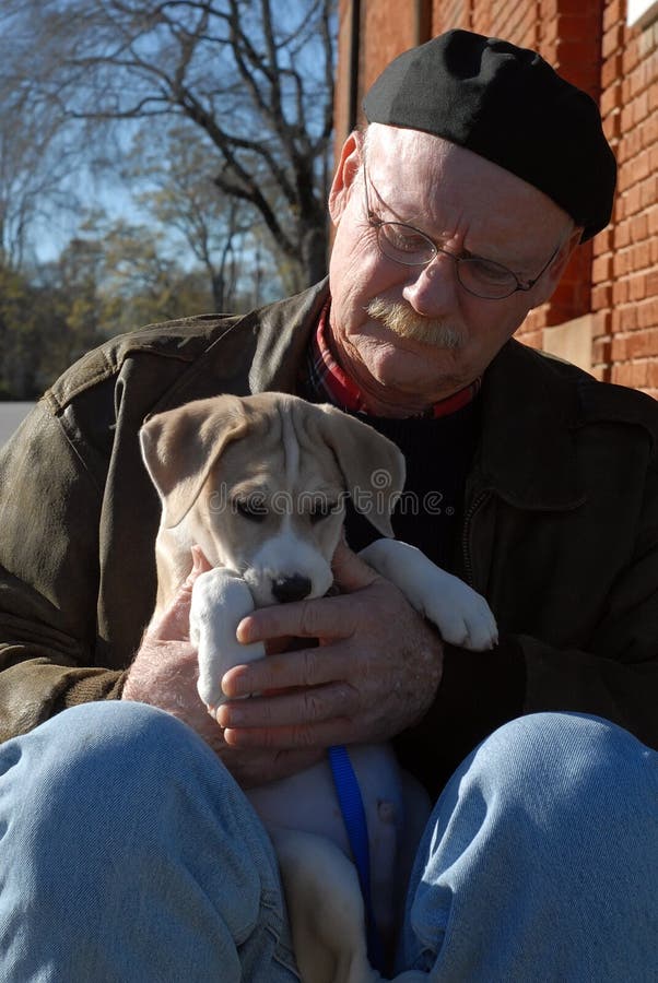 Senior Man Holding Cute Puppy Stock Image - Image of face, brick: 12044459