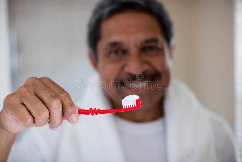 Senior Man Holding a Toothbrush in Bathroom Stock Image - Image of ...