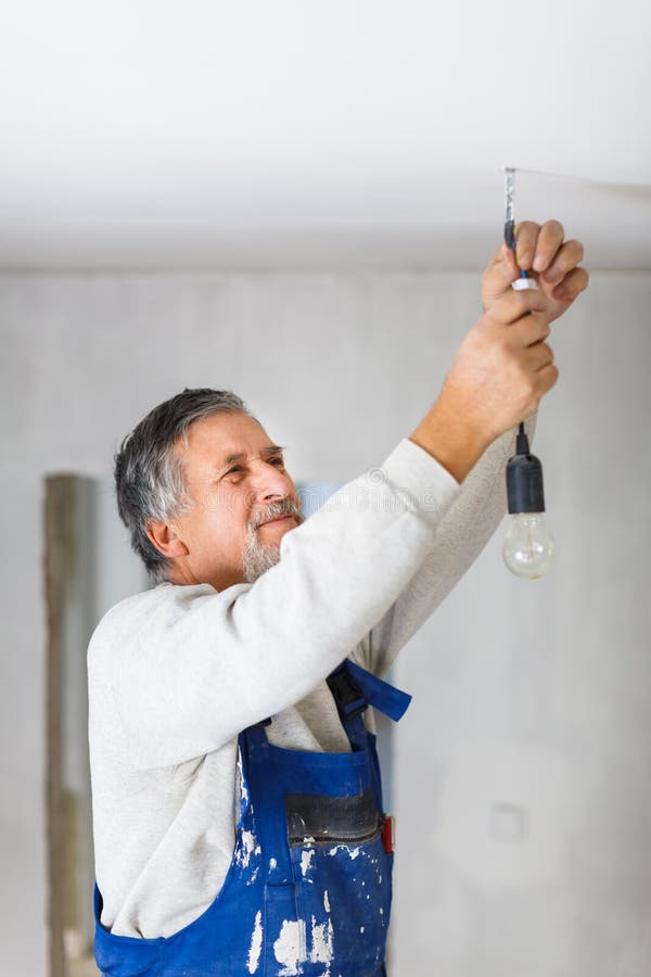 Senior Man Installing a Bulb in a Freshly Renovated Appartment I Stock ...
