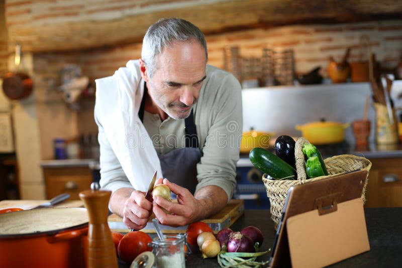 Senior Man in Kitchen Using Tablet during Cooking Stock Image - Image ...