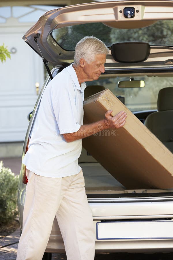 Senior Man Loading Large Package into Back of Car Stock Photo - Image ...