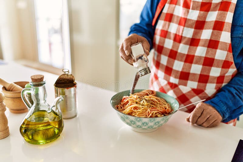 Senior Man Pouring Salt on Spaghetti at Kitchen Stock Photo - Image of ...