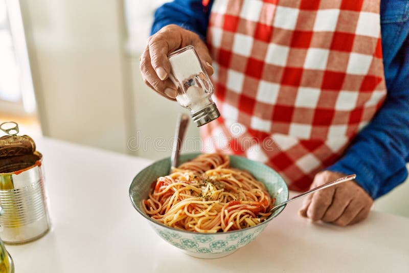 Senior Man Pouring Salt on Spaghetti at Kitchen Stock Photo - Image of ...
