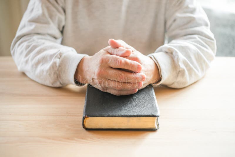 Senior Man Praying Reading An Old Bible In His Hands Stock Image