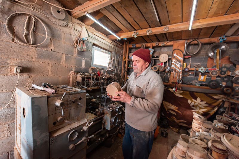 A Senior Man Processing Wooden Dishes in the Workshop in the ...