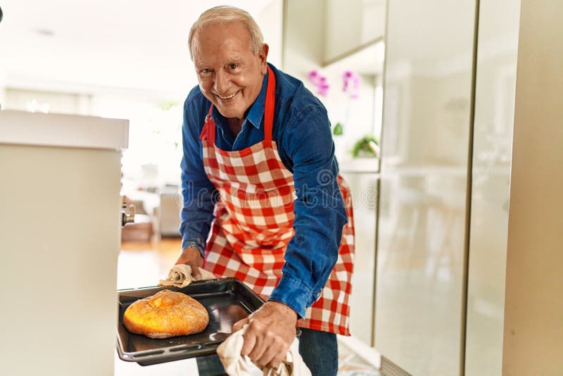 Senior Man Putting Bread in Oven at Kitchen Stock Photo - Image of ...