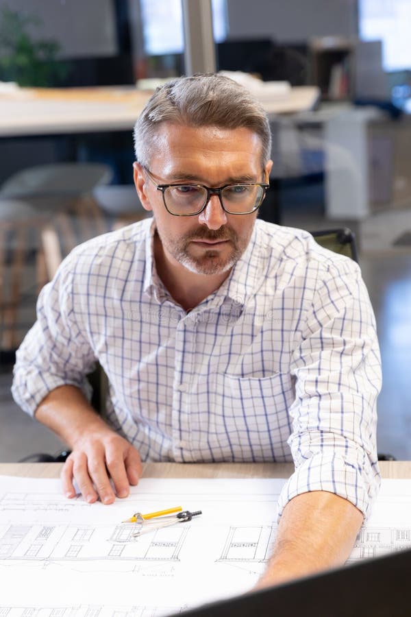Senior Man Reviewing Architectural Blueprints at Modern Office Desk ...