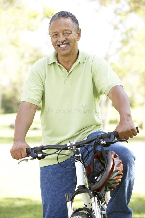 Senior Hispanic Man Riding Bike in Park Stock Image - Image of middle ...