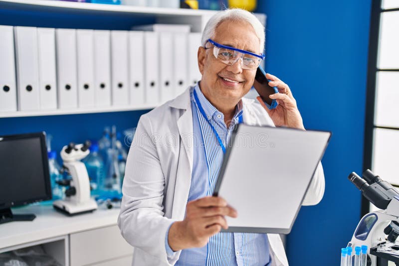 Senior Man Scientist Talking on the Smartphone Writing on Document at ...