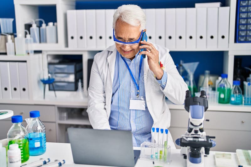 Senior Man Scientist Using Laptop Talking on the Smartphone at ...