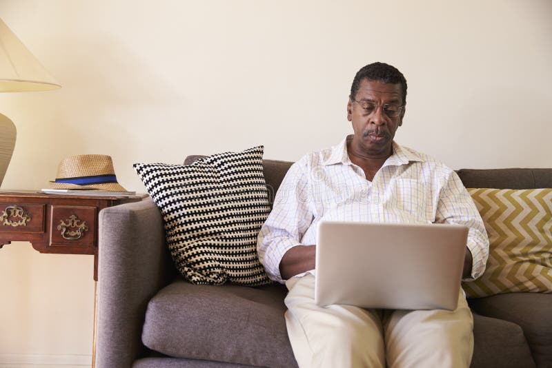Senior Man Sitting on Sofa at Home Using Laptop Stock Image - Image of ...