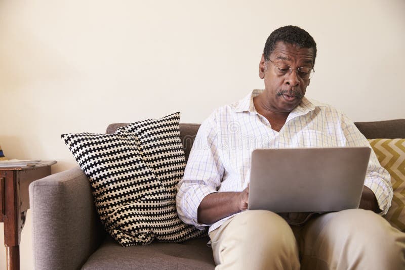 Senior Man Sitting on Sofa at Home Using Laptop Stock Image - Image of ...