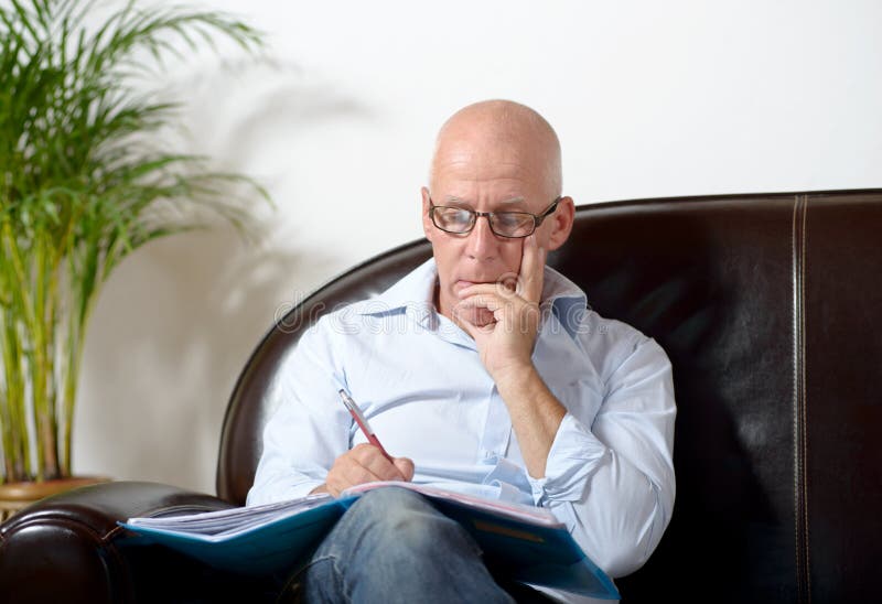 A Senior Man Sitting Taking Notes Stock Photo - Image of desk, people ...