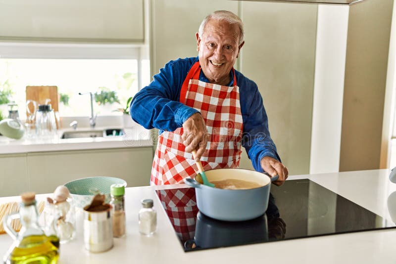 Senior Man Smiling Confident Cooking Spaghetti at Kitchen Stock Photo ...