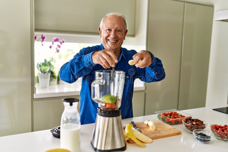 Senior Man Smiling Confident Putting Banana in Blender at Kitchen Stock ...