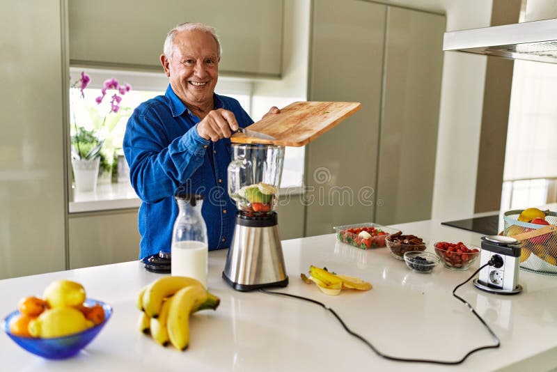 Senior Man Smiling Confident Putting Banana in Blender at Kitchen Stock ...