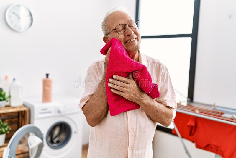 Senior Man Smiling Confident Touching Face with Towel at Laundry Room ...