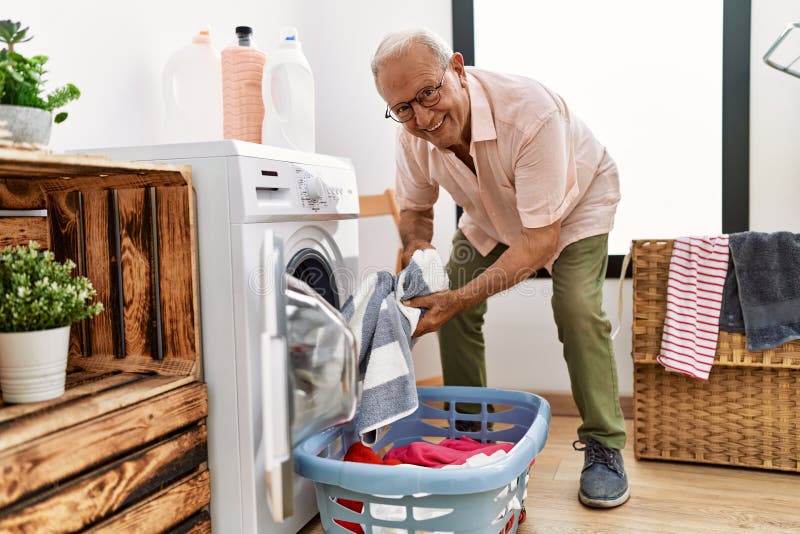 Senior Man Smiling Confident Washing Clothes at Laundry Room Stock ...