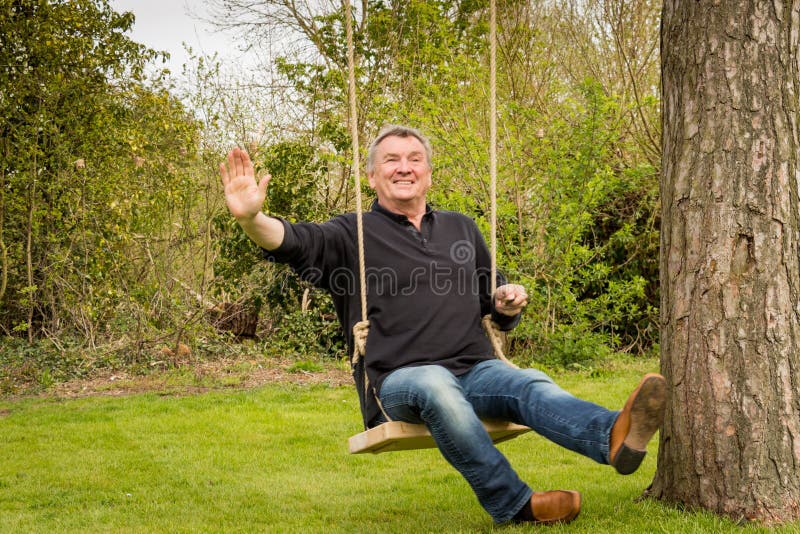 Senior Man on a Tree Swing in the Garden Stock Photo - Image of ...