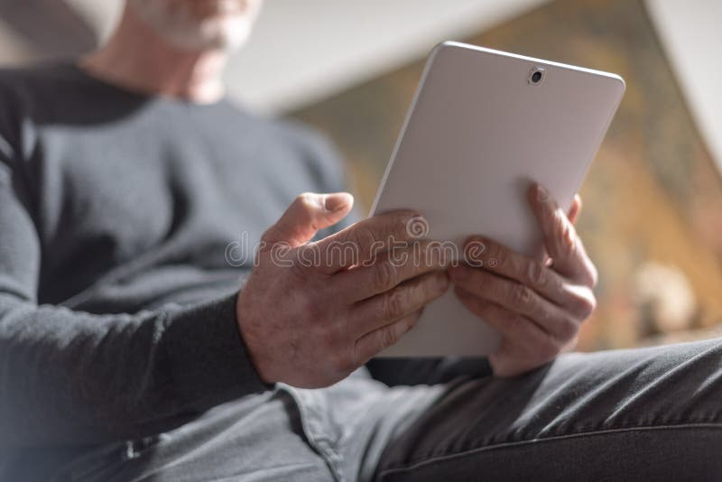 Senior Man Using His Tablet, Hard Light Effect Stock Image - Image of ...