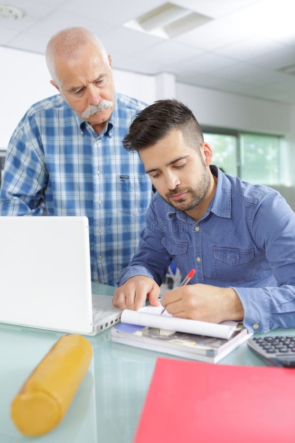 Senior Man Watching Younger Man Writing Stock Image - Image of pencil ...