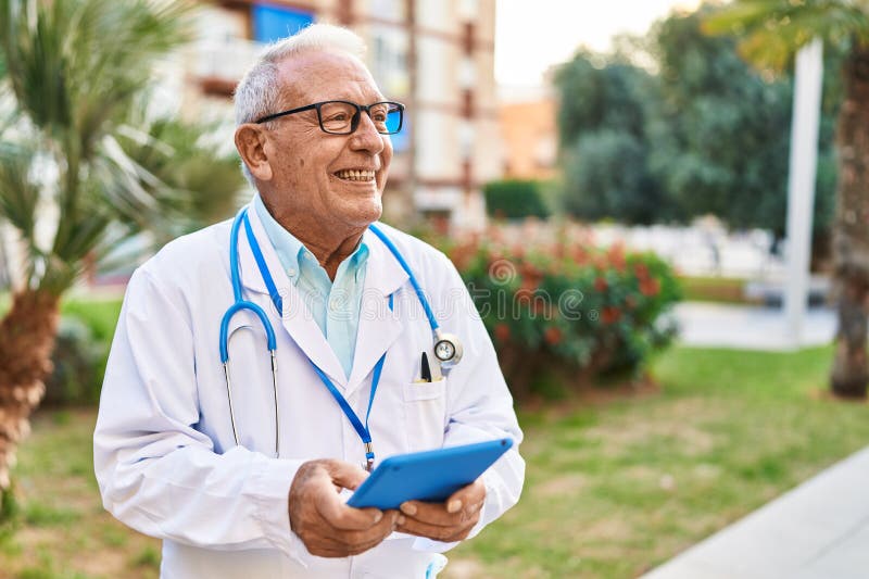 Senior Man Wearing Doctor Uniform Using Touchpad at Park Stock Image ...