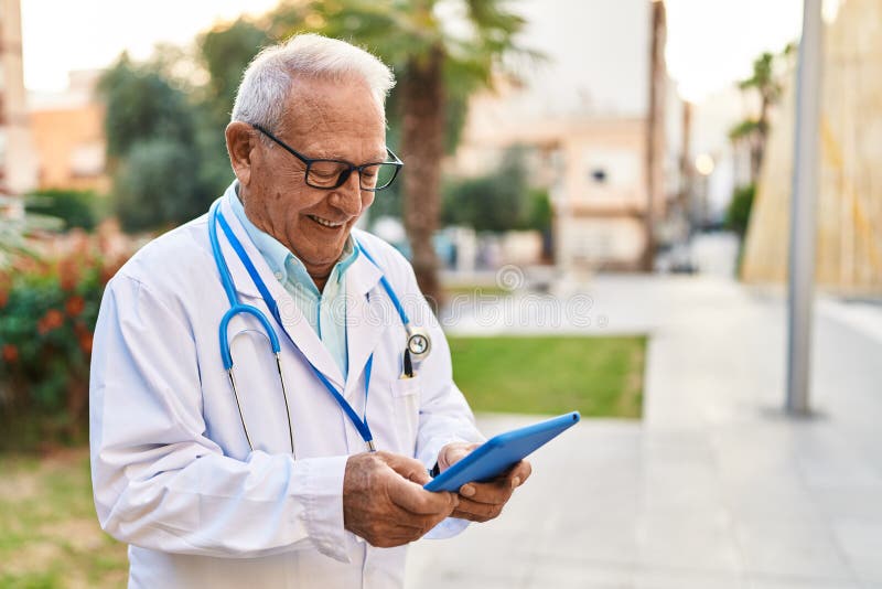 Senior Man Wearing Doctor Uniform Using Touchpad at Park Stock Photo ...