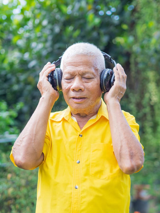 Senior Man Wearing Wireless Headphones For Listening To A Favorite Song