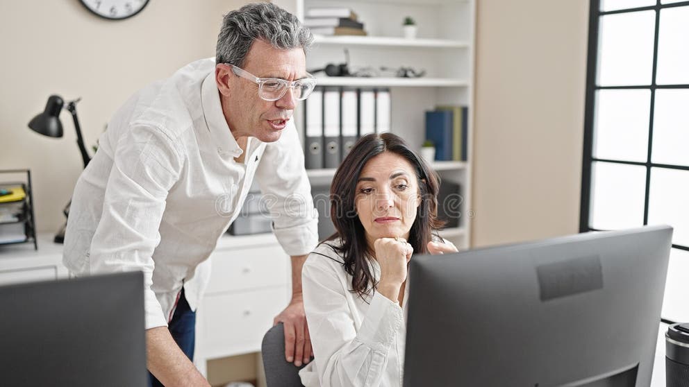 Senior Man and Woman Business Workers Using Computer Speaking at Office ...