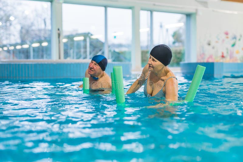 Senior Man And Woman Doing Aerobic Water Exercises In The Swimming Pool