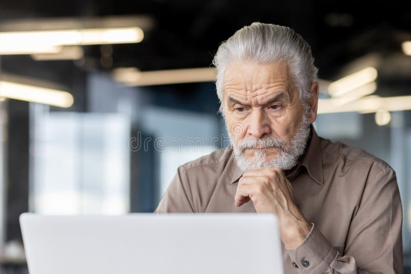 Senior Man Working on Laptop in Office, Serious Facial Expression ...
