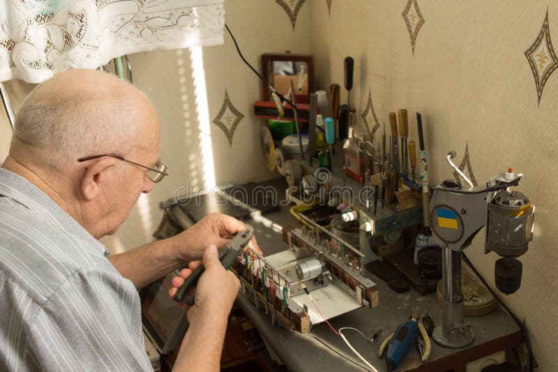 Senior Man Working at a Small Work Bench Stock Image - Image of ...