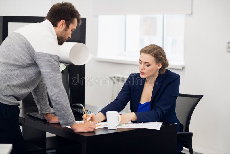 A Senior Manager Explaining Something To Her Team Member, while Stock ...