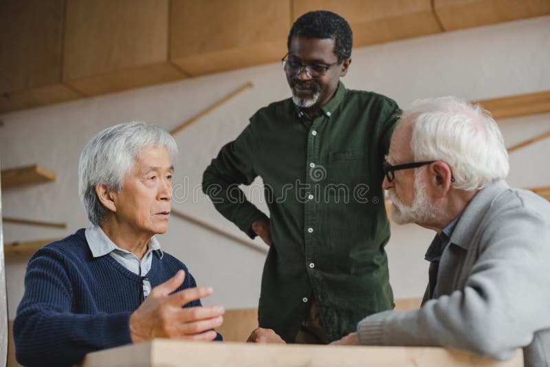 Senior men talking in cafe stock image. Image of handsome - 105050259