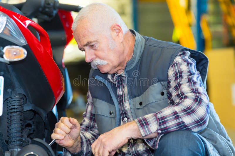 Senior Motorcycle Mechanic Working at Workshop Stock Photo - Image of ...