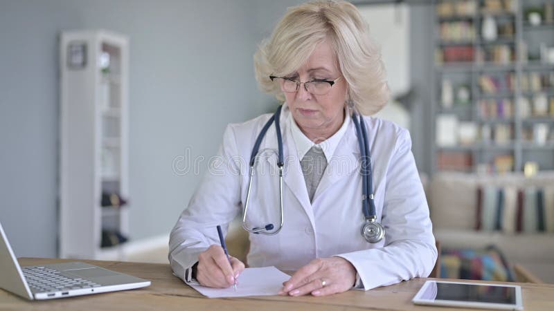 Senior Old Female Doctor Doing Paperwork Stock Image - Image of ...