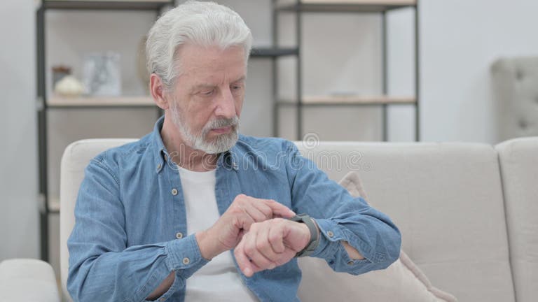 Old Man Using Smartwatch while Sitting on Sofa Stock Image - Image of ...