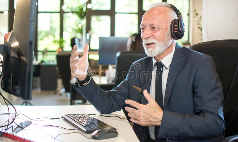 Senior Operator Agent in Headset Explaining Something To a Client ...