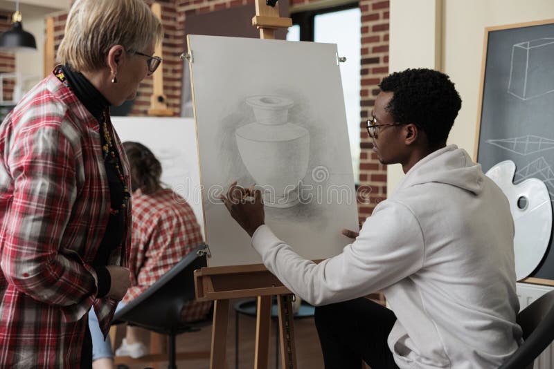 Senior Painter Teacher Explaining Illustration Technique To Young ...