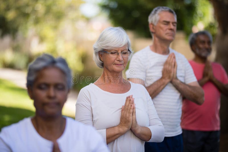 Senior People Meditating in Prayer Position while Standing Stock Photo ...