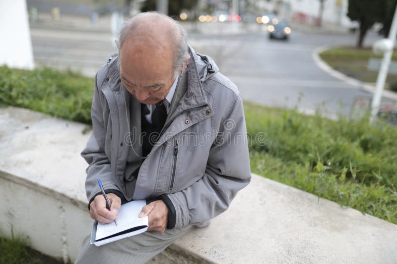 Senior Professor Writing Notes Outdoors on University Campus Stock ...