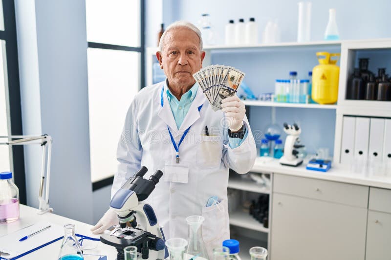 Senior Scientist with Grey Hair Working at Laboratory Holding Dollars ...