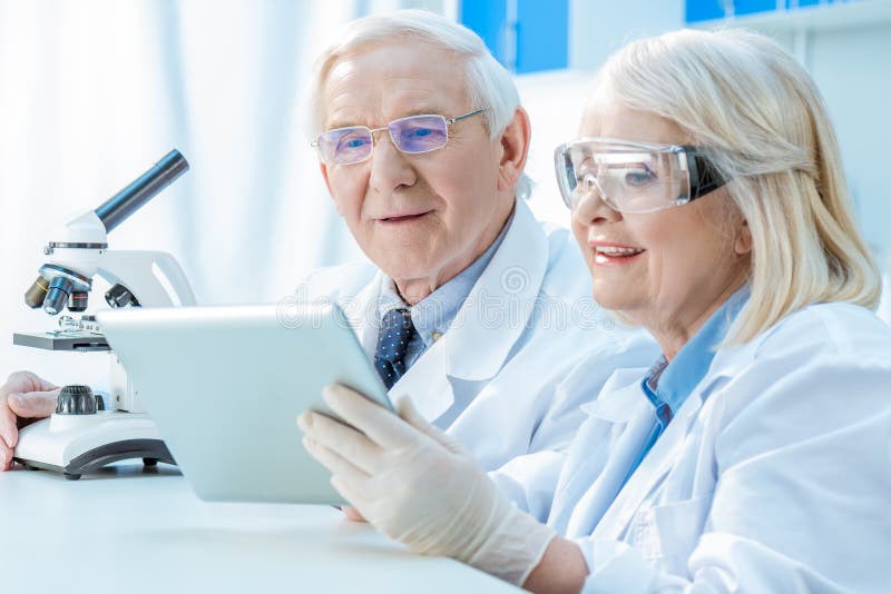 Senior Scientists Working with Digital Tablet and Microscope Stock ...